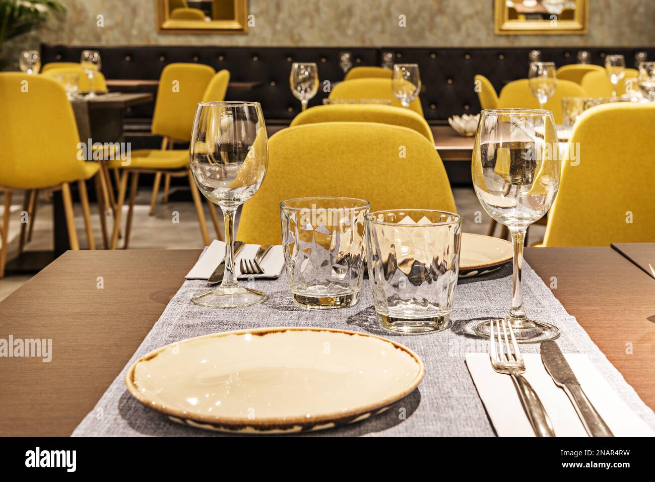 Tables in the dining room of a restaurant with service set up with ...