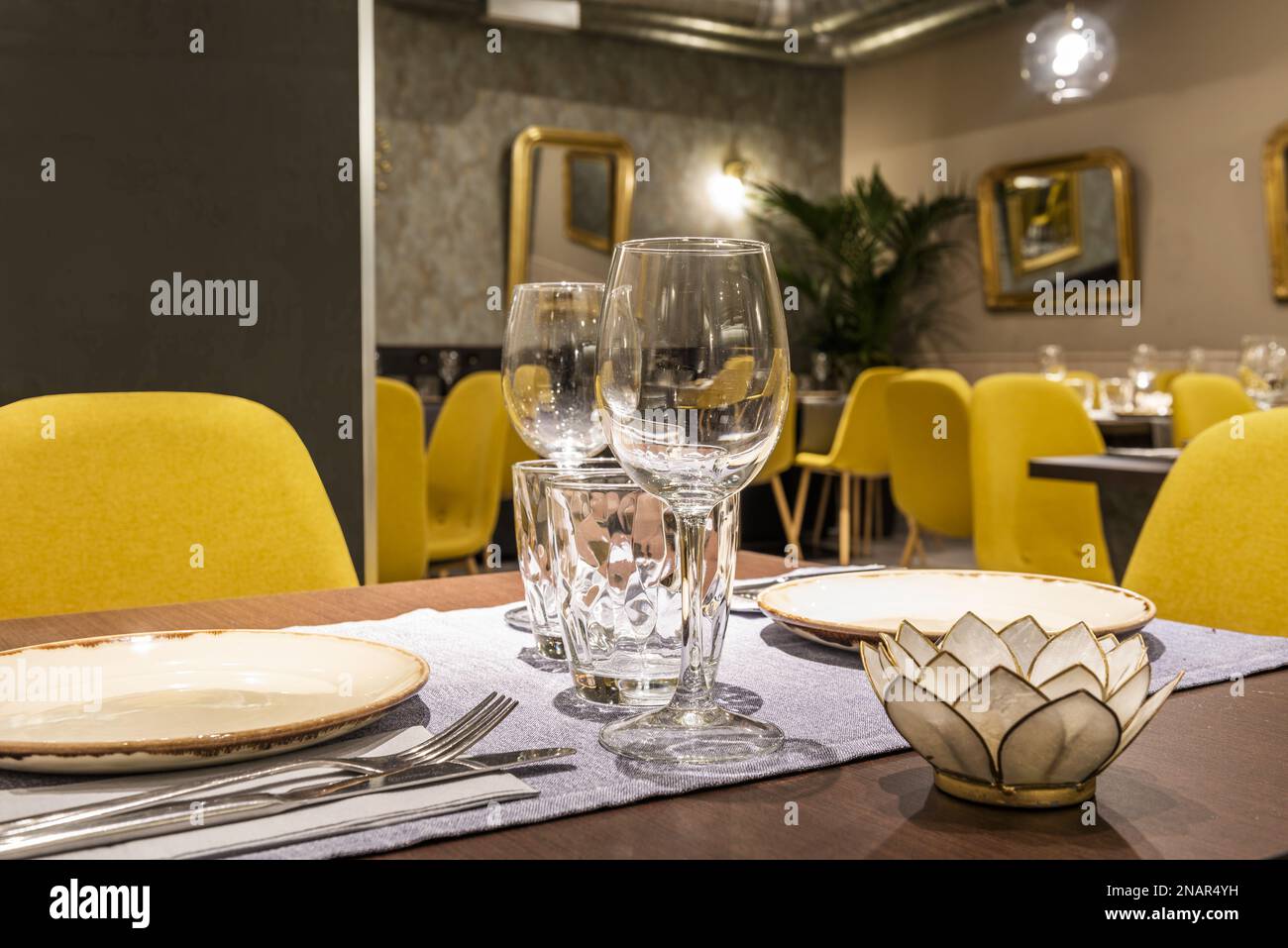 Tables in the dining room of a restaurant with a service set up with ...