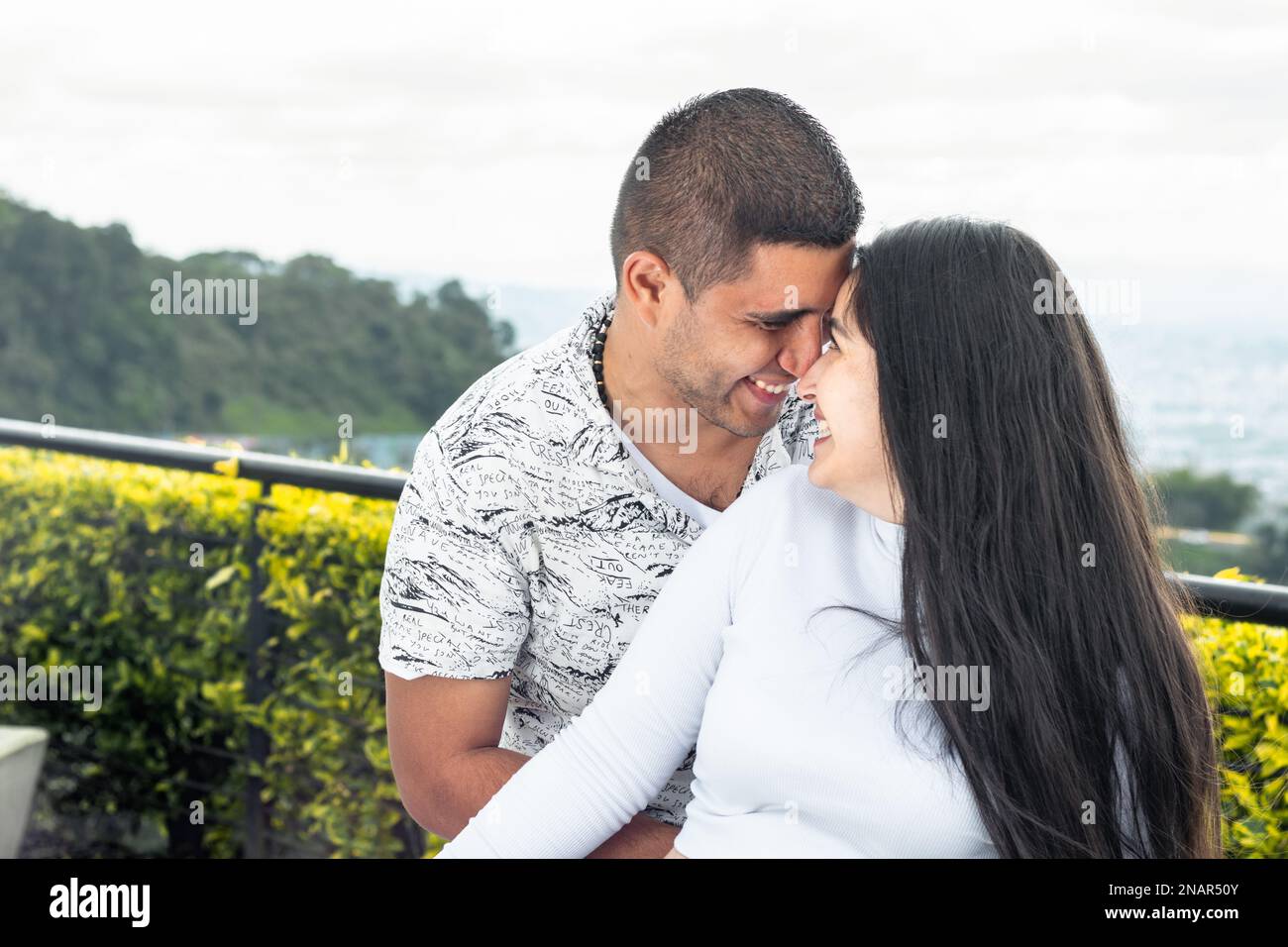 beautiful young latin couple, looking into each other's eyes while smiling. concept of real love ...