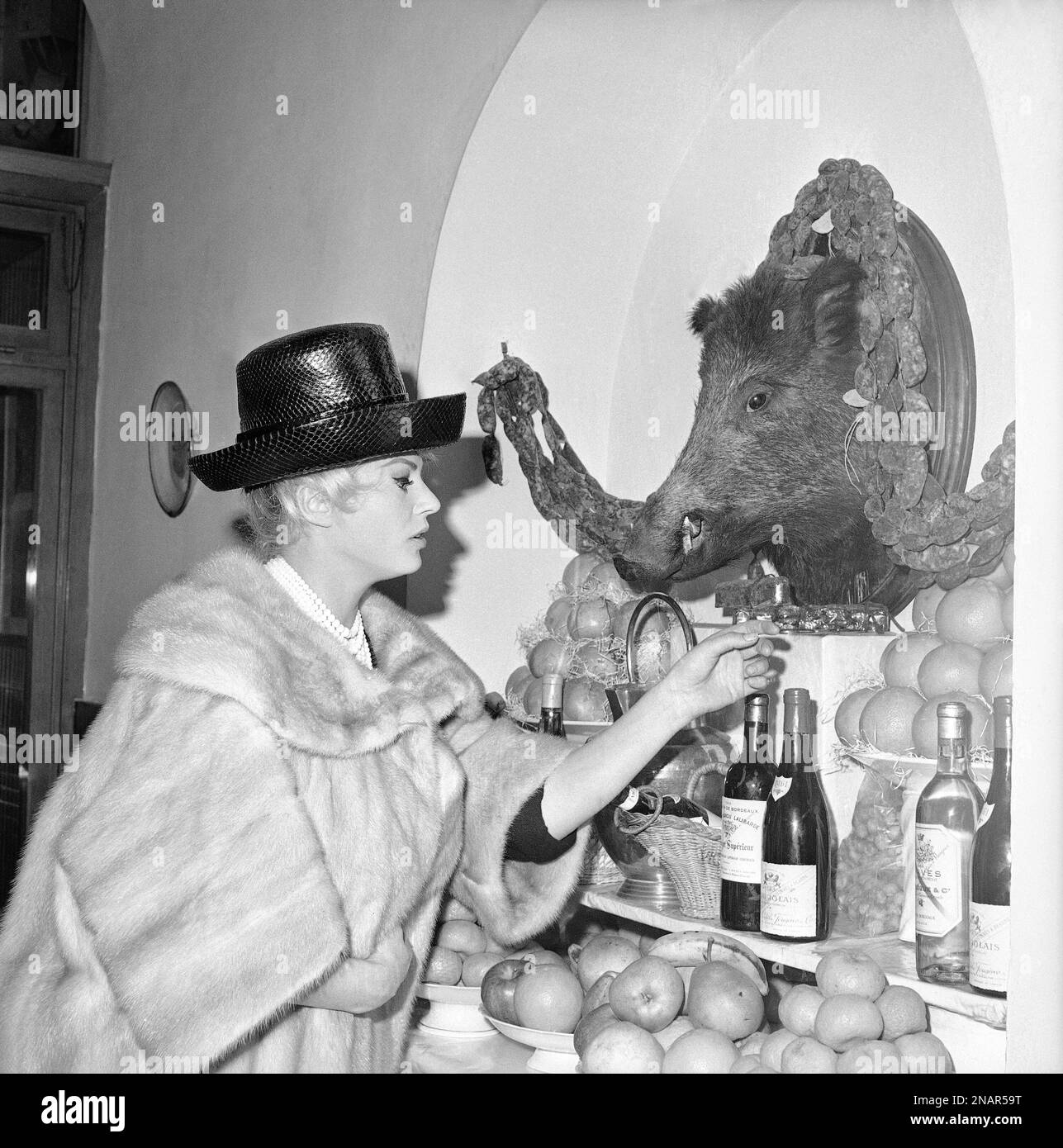 Swedish-born actress Anita Ekberg chooses a bottle of wine for a lunch ...