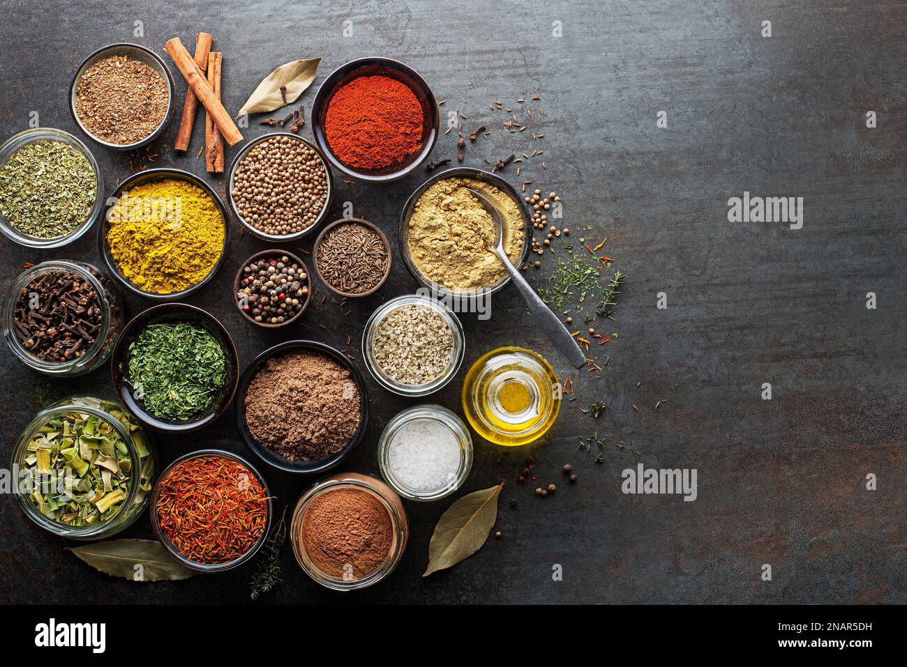 Colorful herbs and spices for cooking. Indian spices. On grey stone ...