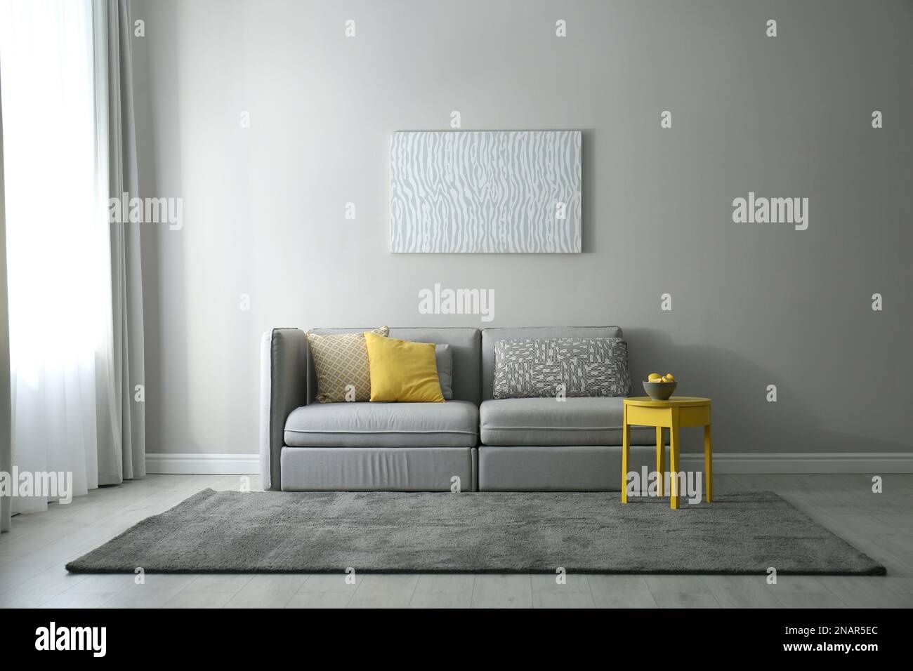 Stylish living room with sofa. Interior design in grey and yellow ...