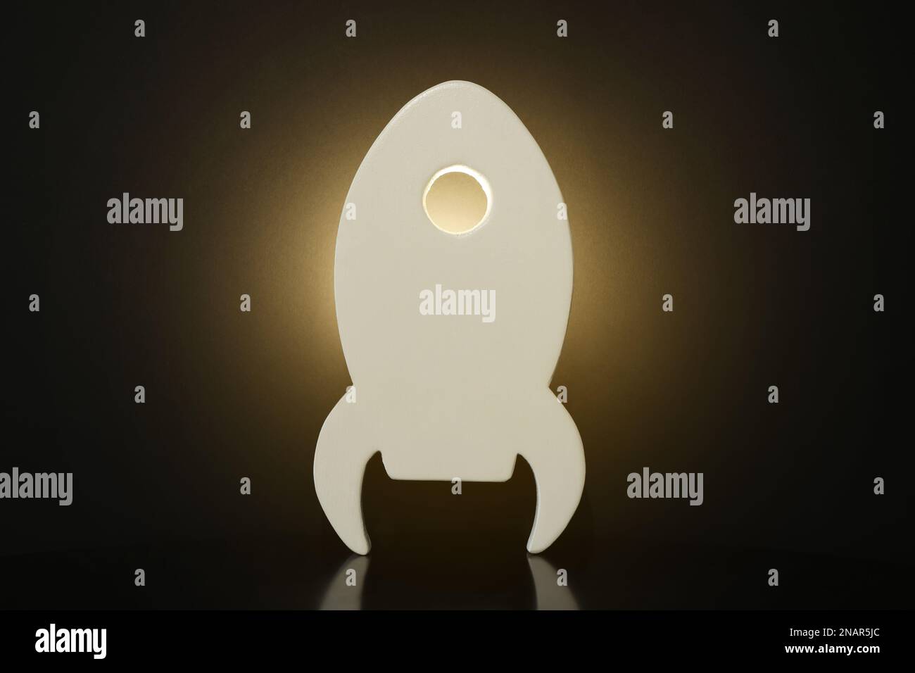 Rocket shaped glowing night lamp on black background Stock Photo - Alamy