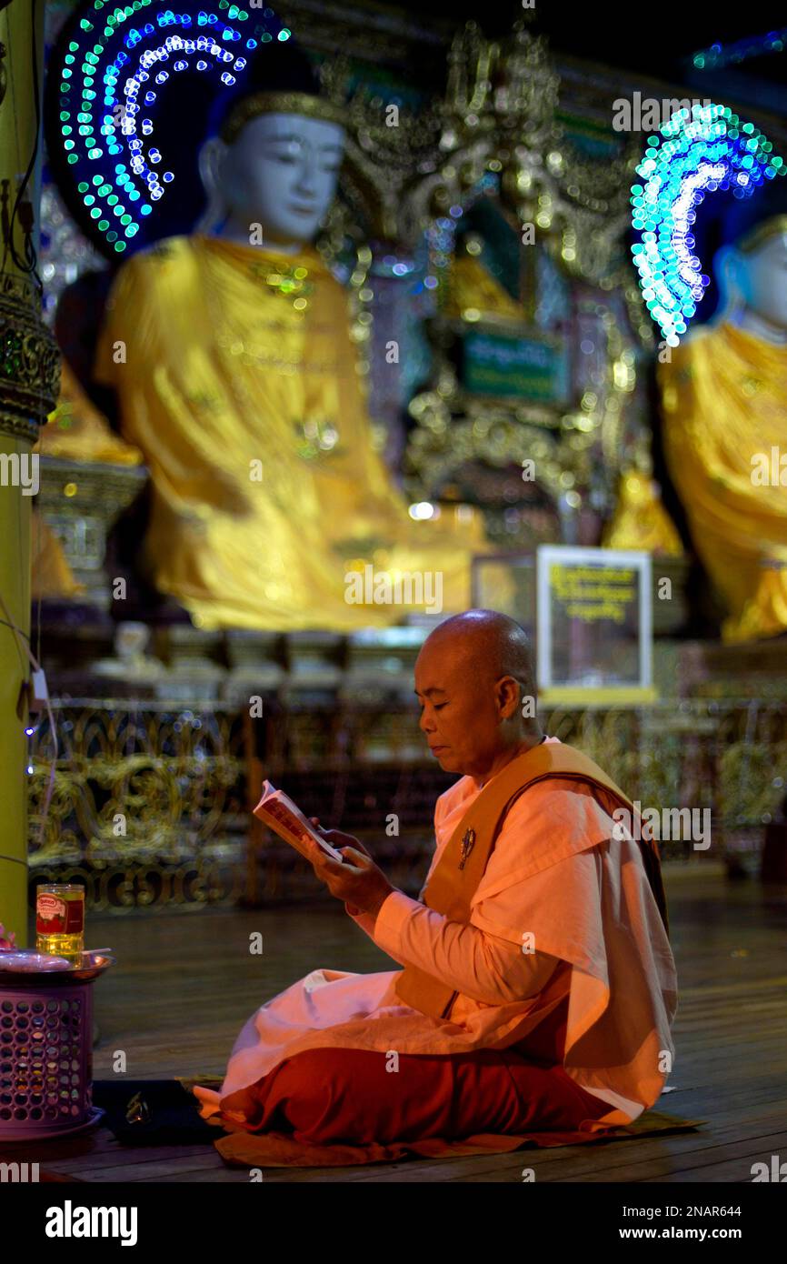 A Myanmar nun prays at the landmark Shwedagon Pagoda in Yangon, Tuesday ...