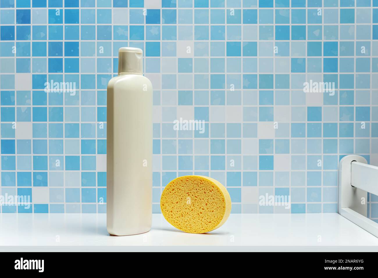One liter bottle of shampoo with a yellow synthetic sponge on a white ...