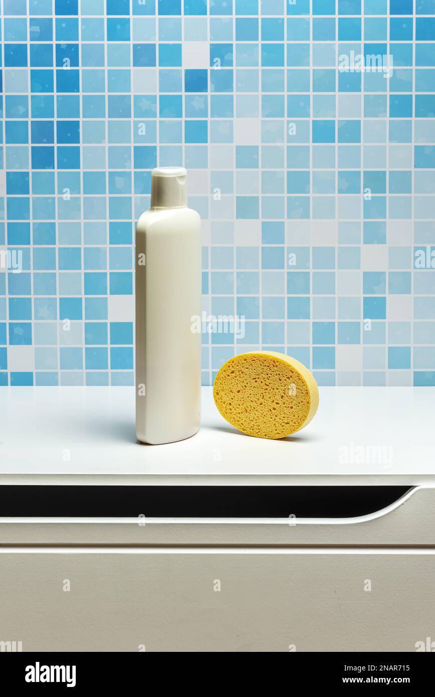 One liter bottle of shampoo with a yellow synthetic sponge on a white ...