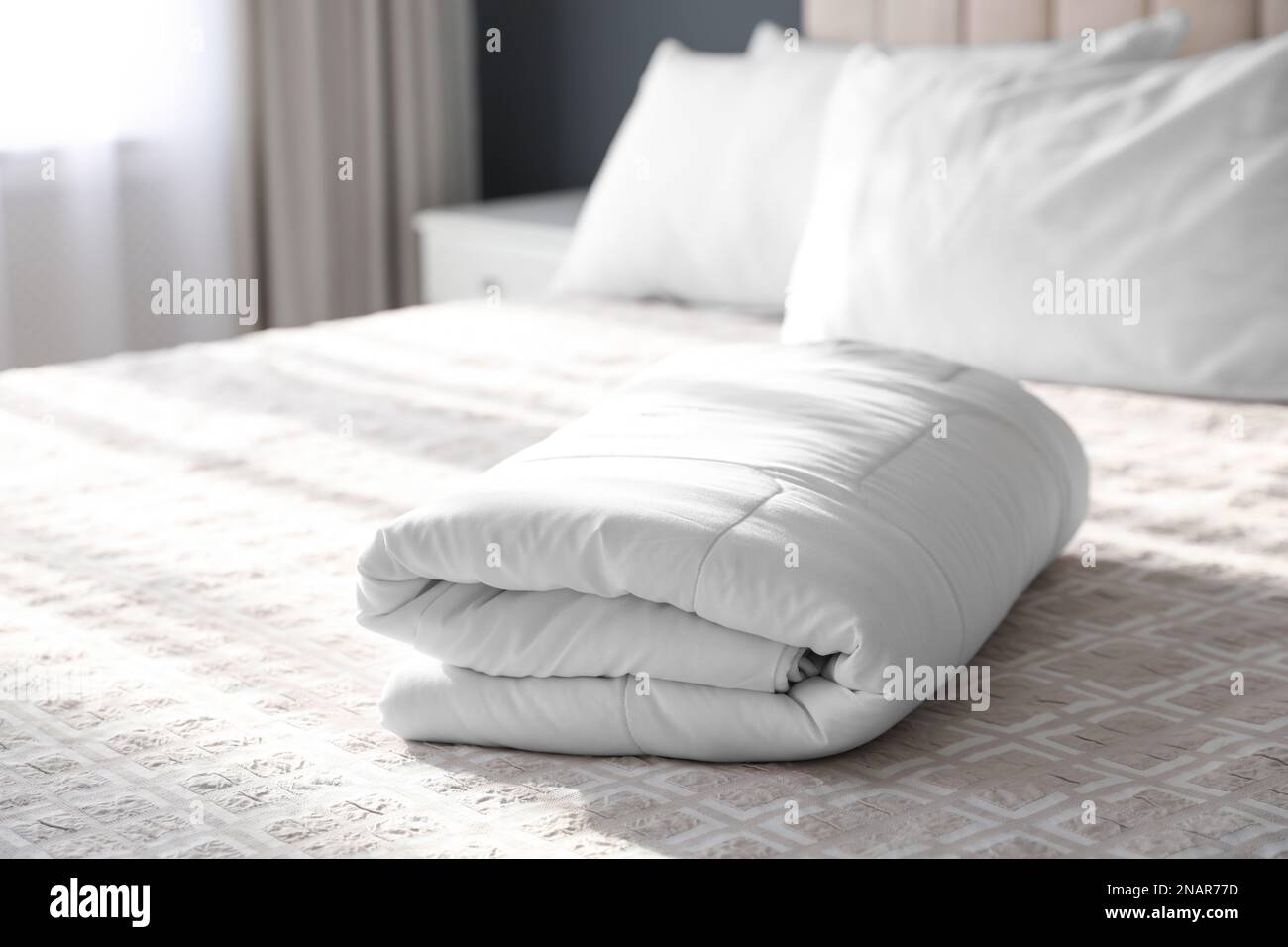 Folded clean blanket on bed in room Stock Photo - Alamy