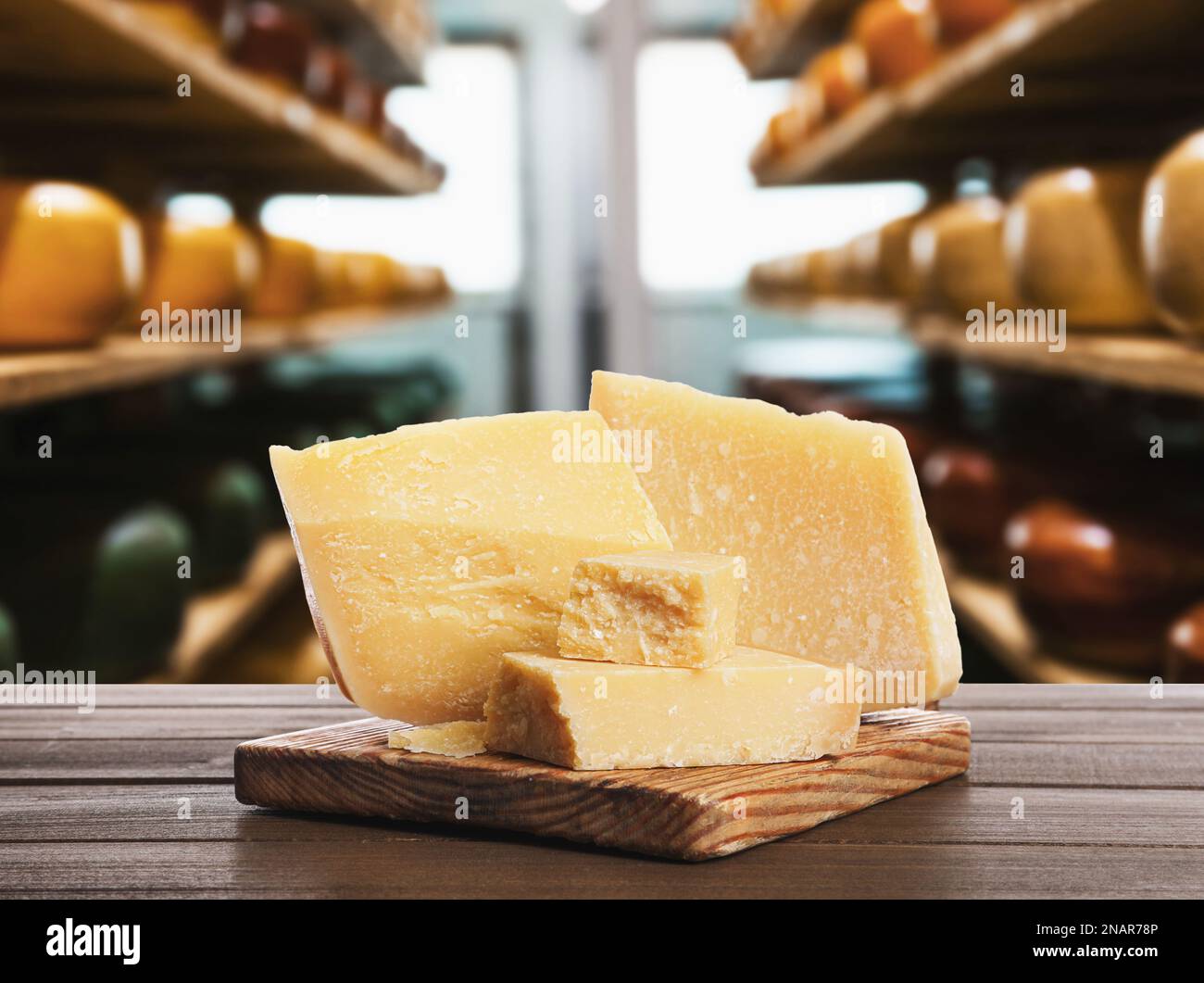 Delicious parmesan cheese on wooden table in warehouse Stock Photo - Alamy