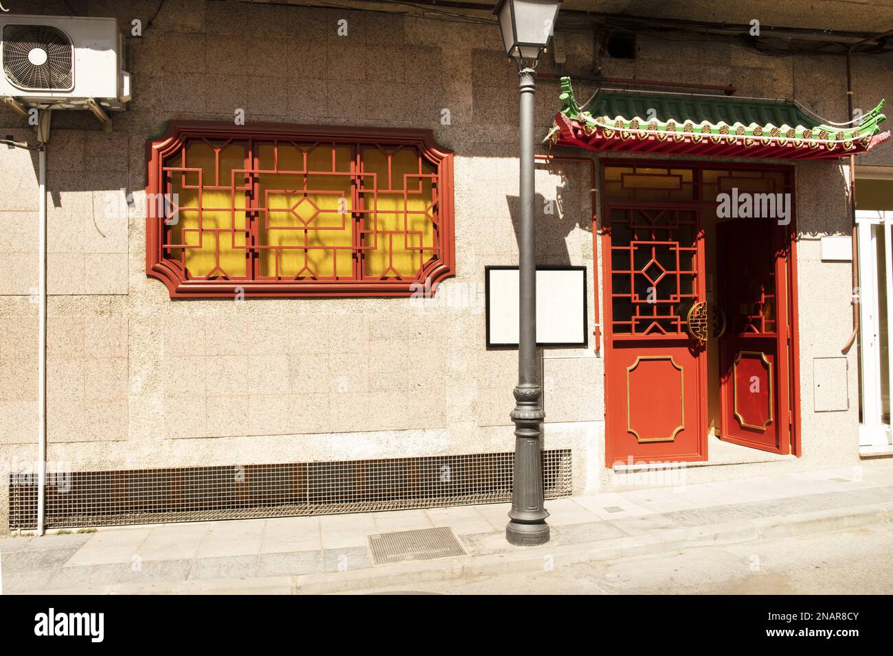 Entrance facade of a Chinese restaurant with a pagoda roof on a sunny ...