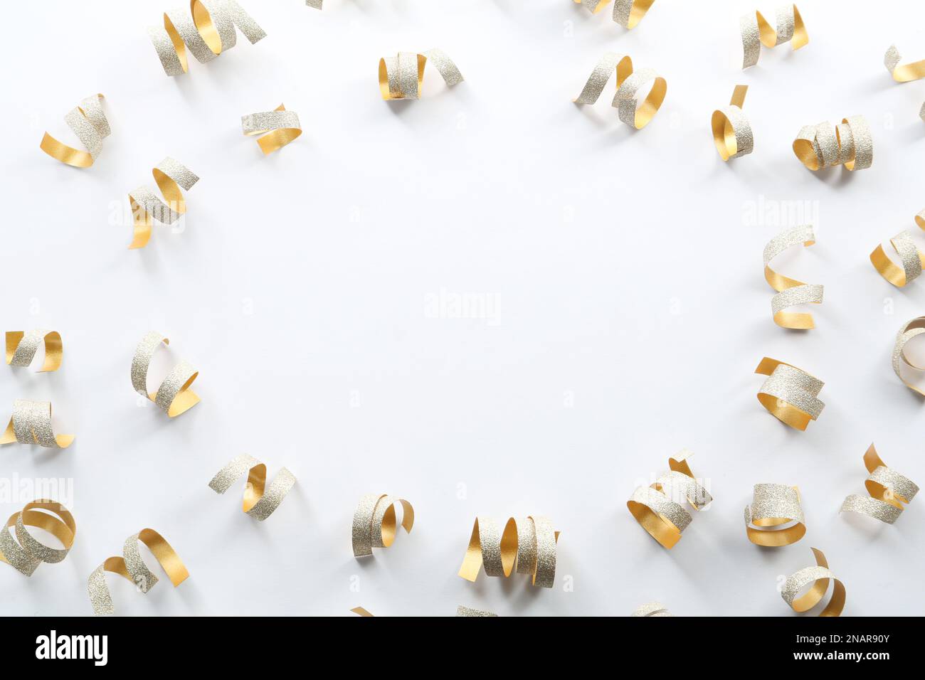 Frame of shiny serpentine streamers on white background, above view ...