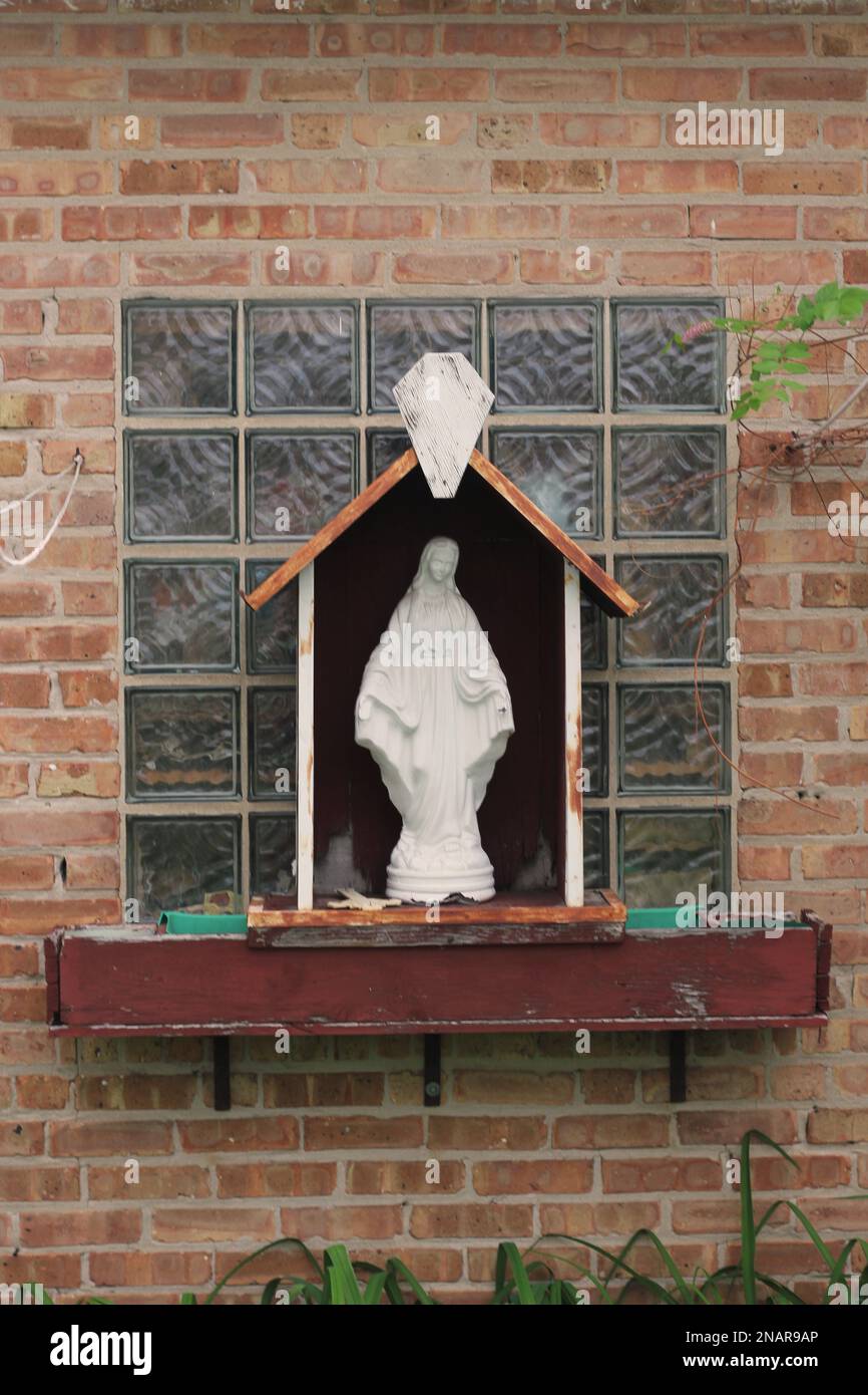 Typical common statue of the Virgin Mary standing against a common ...