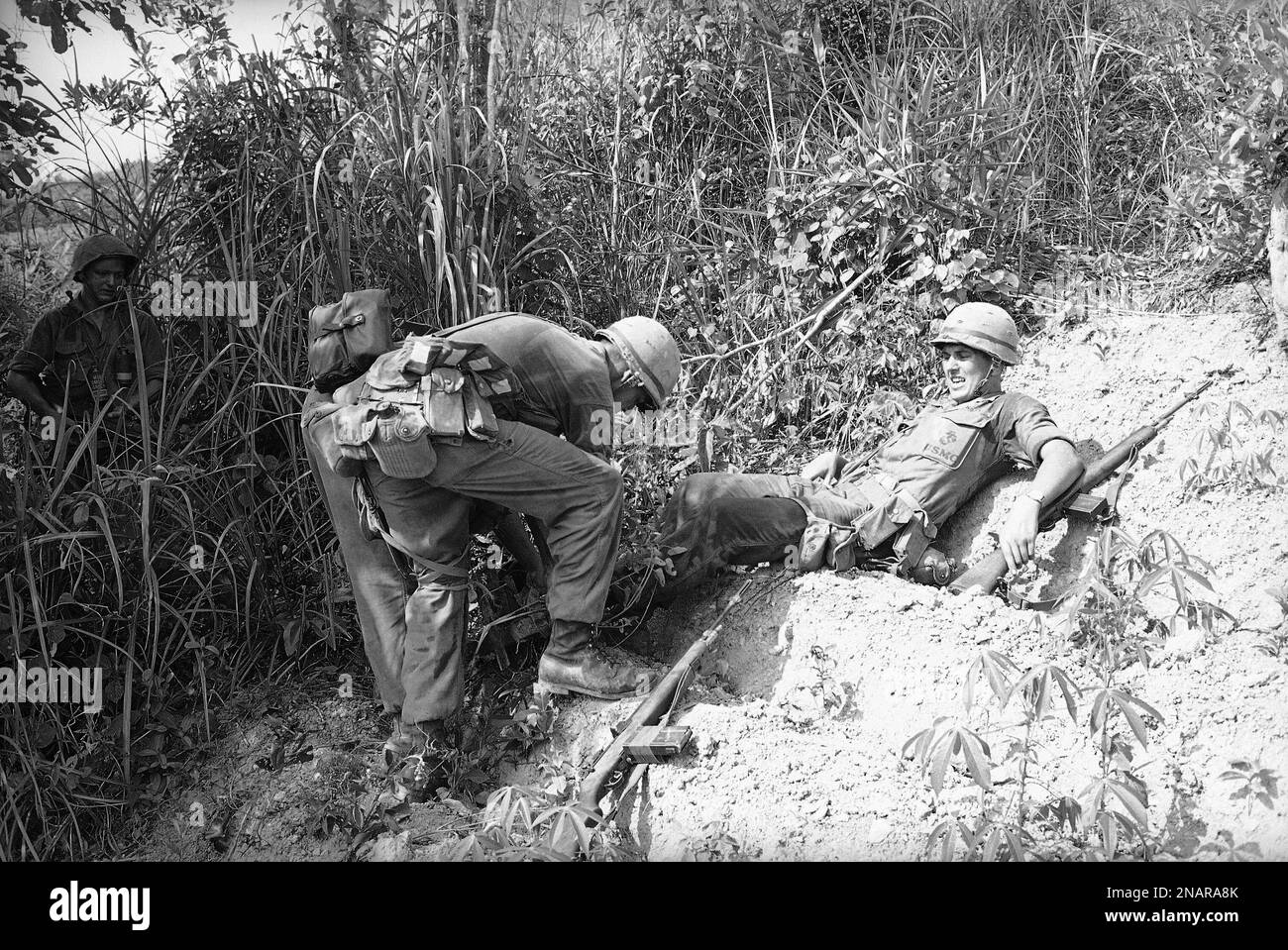 Marine Pfc. Allan Nehls of Milltown, Wisc., is aided by a fellow Marine ...