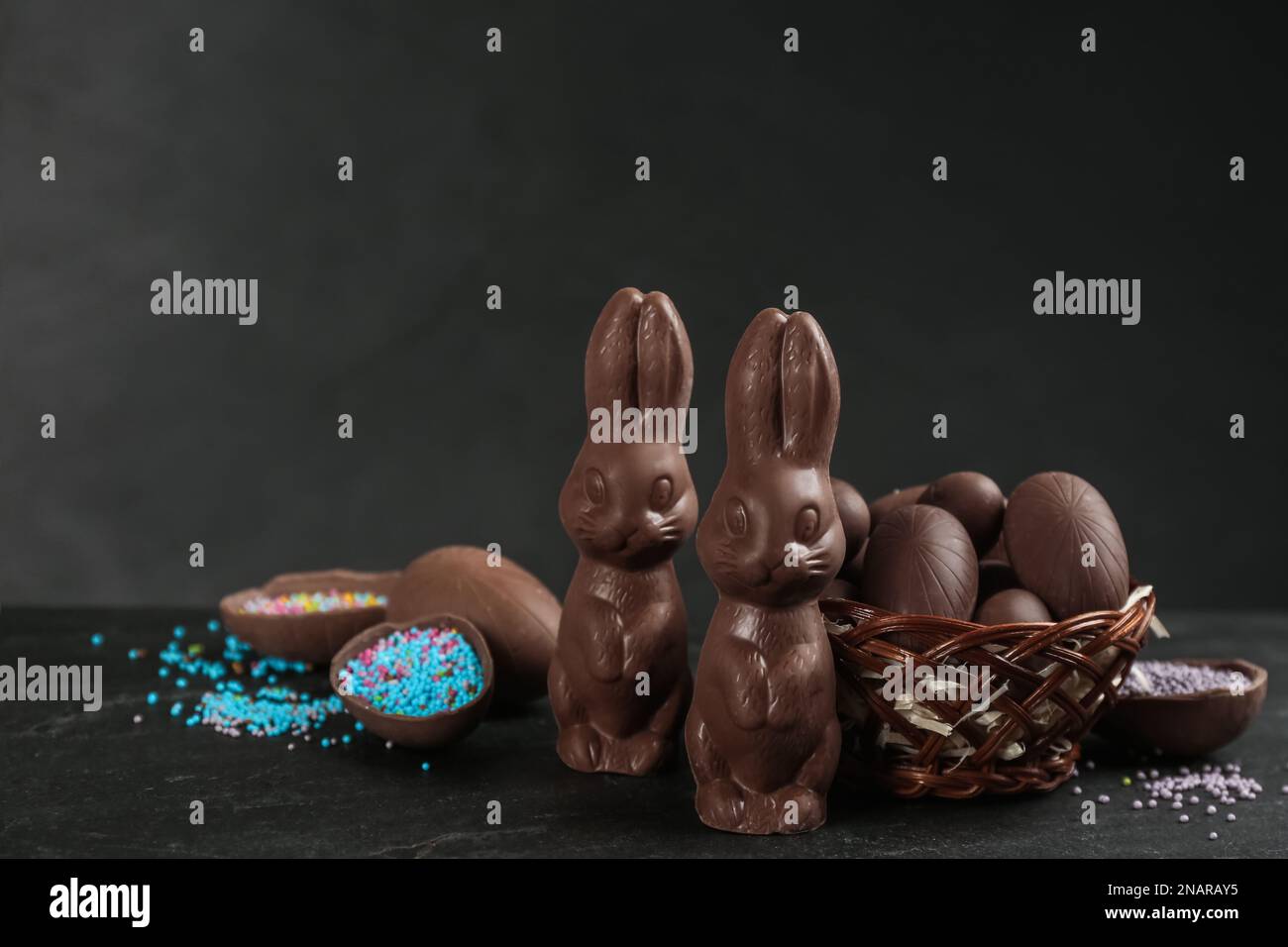 Chocolate Easter bunnies and eggs on black table. Space for text Stock ...