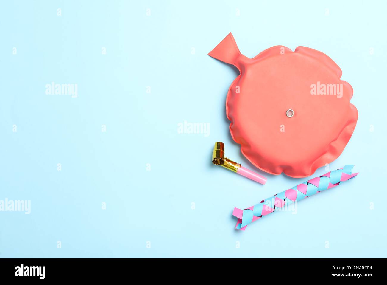 Whoopee cushion, party blower and chinese finger trap on light blue ...