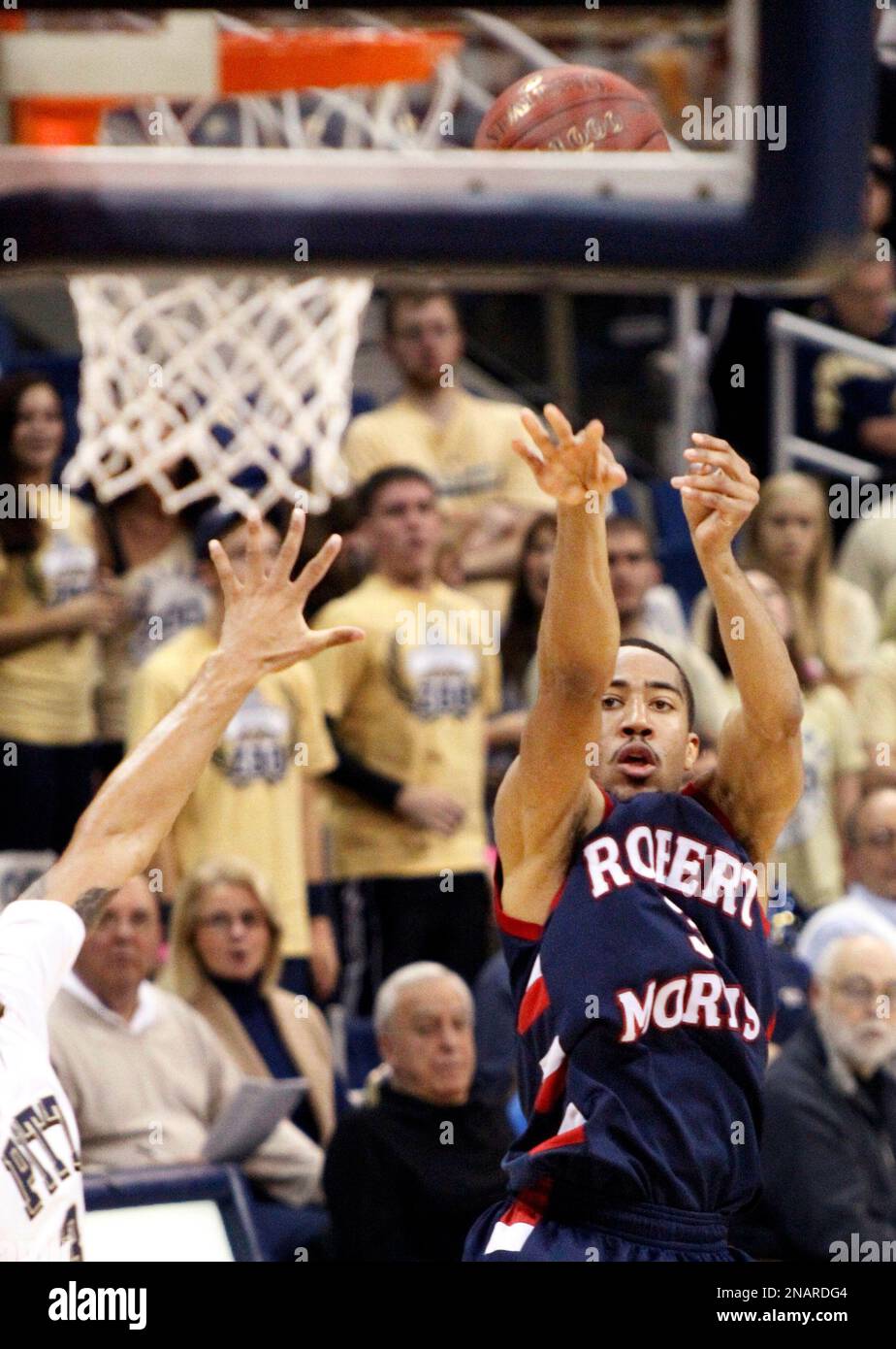 Robert Morris' Coron Williams, right, shoots a three-point shot as ...