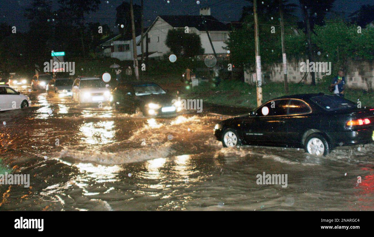 Motorists push through a flooded street during heavy rain which has ...