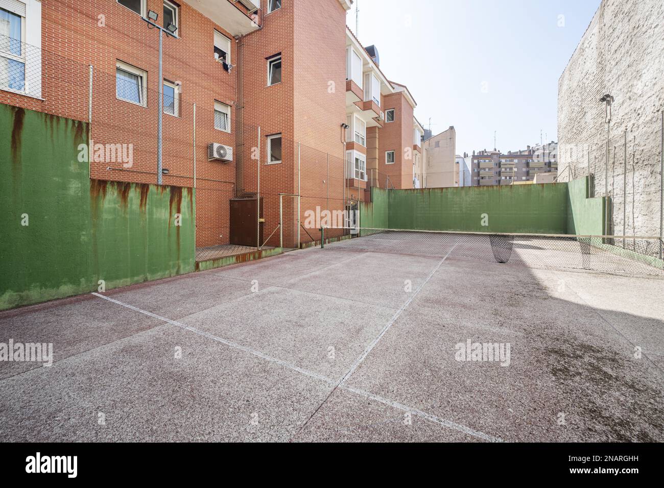 An urban tennis court in a block courtyard between buildings Stock ...