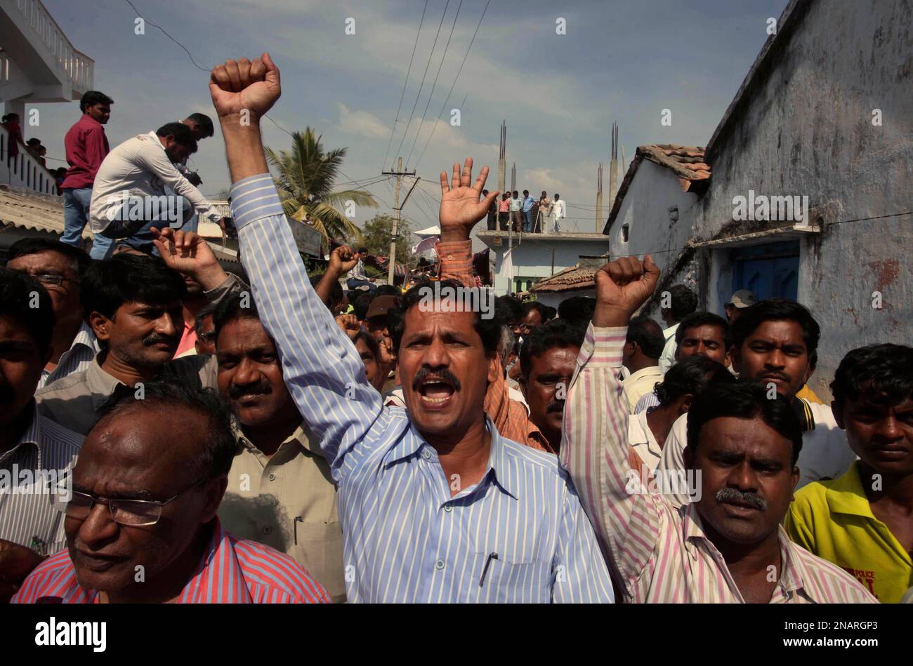 Relatives and supporters shout slogans as they accompany the body of ...