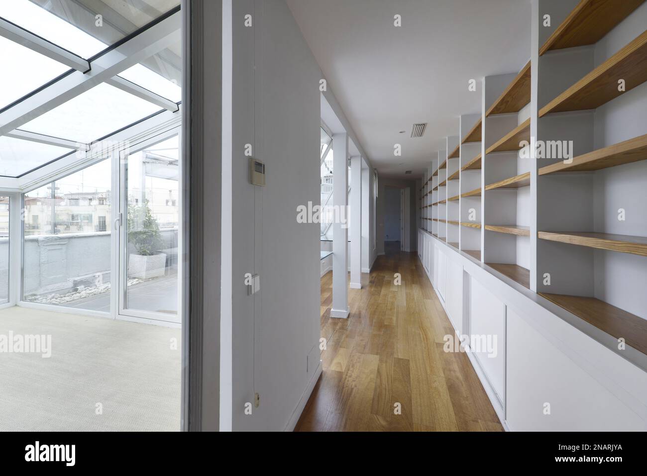 Long corridor of a penthouse apartment with a glazed terrace and a long ...