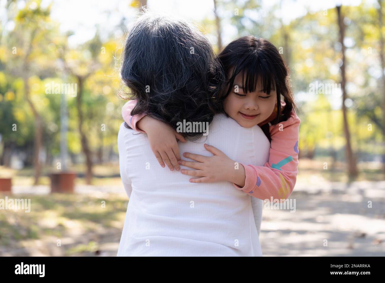 An Cute Granddaughter Giving Hug Cuddling To Her Grandmother Having