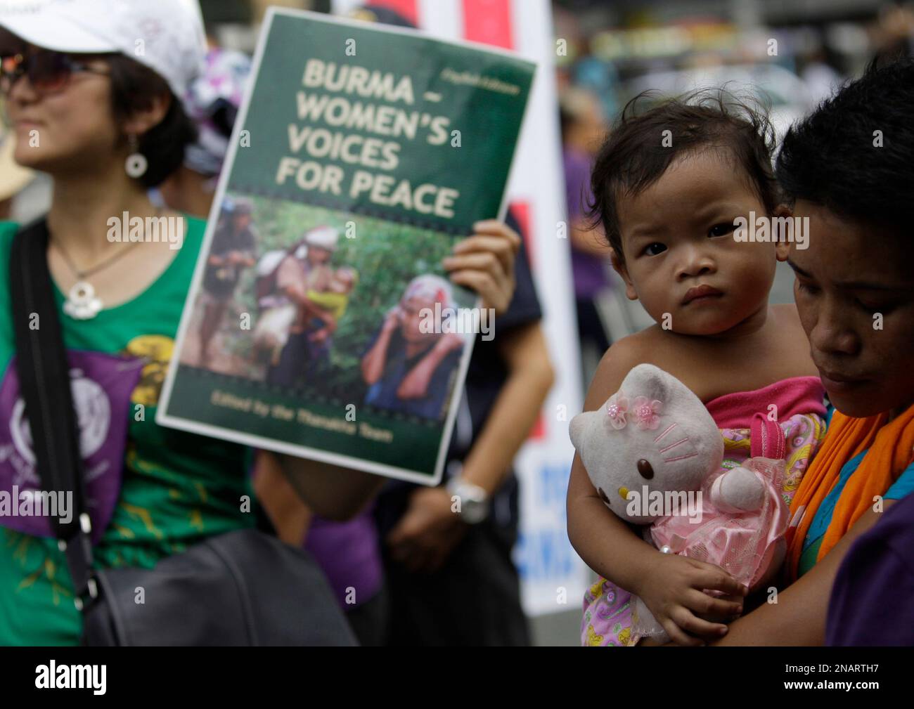 A Filipino child is carried by her mother during a demonstration to ...