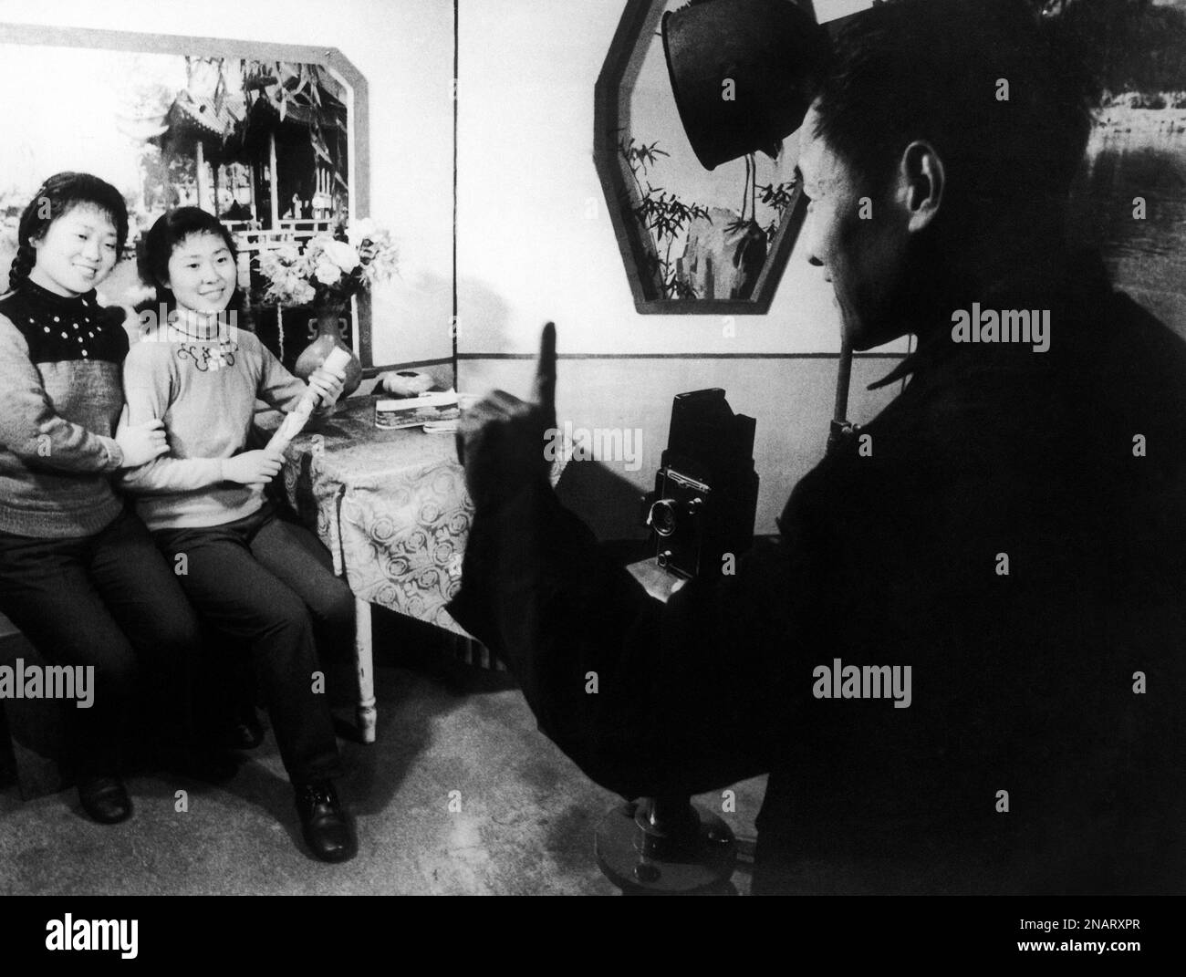 A Chinese photographer poses two sisters in a Jinan (Tsinan ...