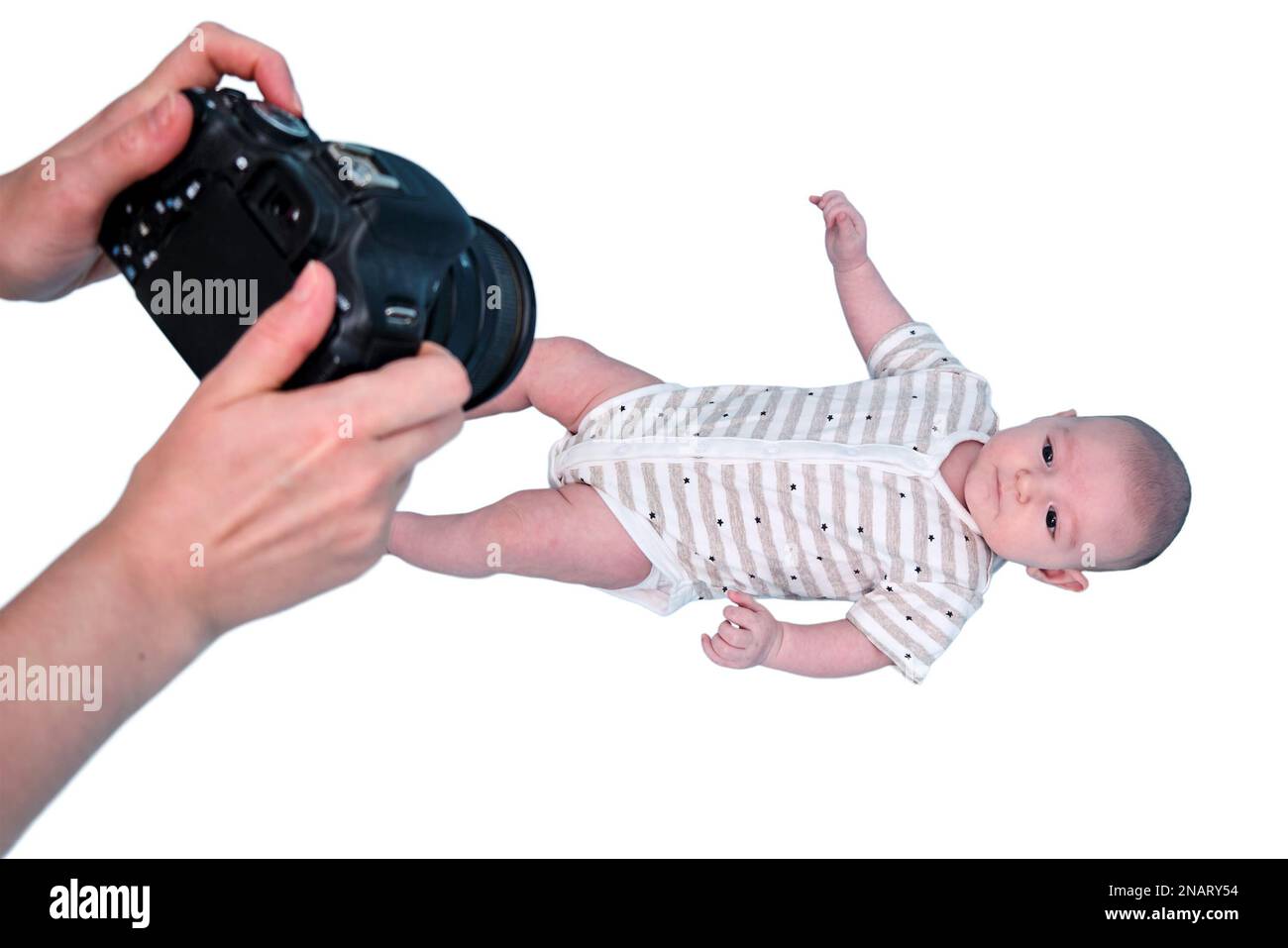 A photographer takes pictures of a newborn baby with a camera in studio ...