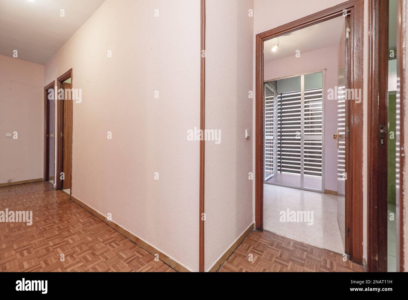 Hallway of a home with checkerboard hardwood floors and sapele wood ...