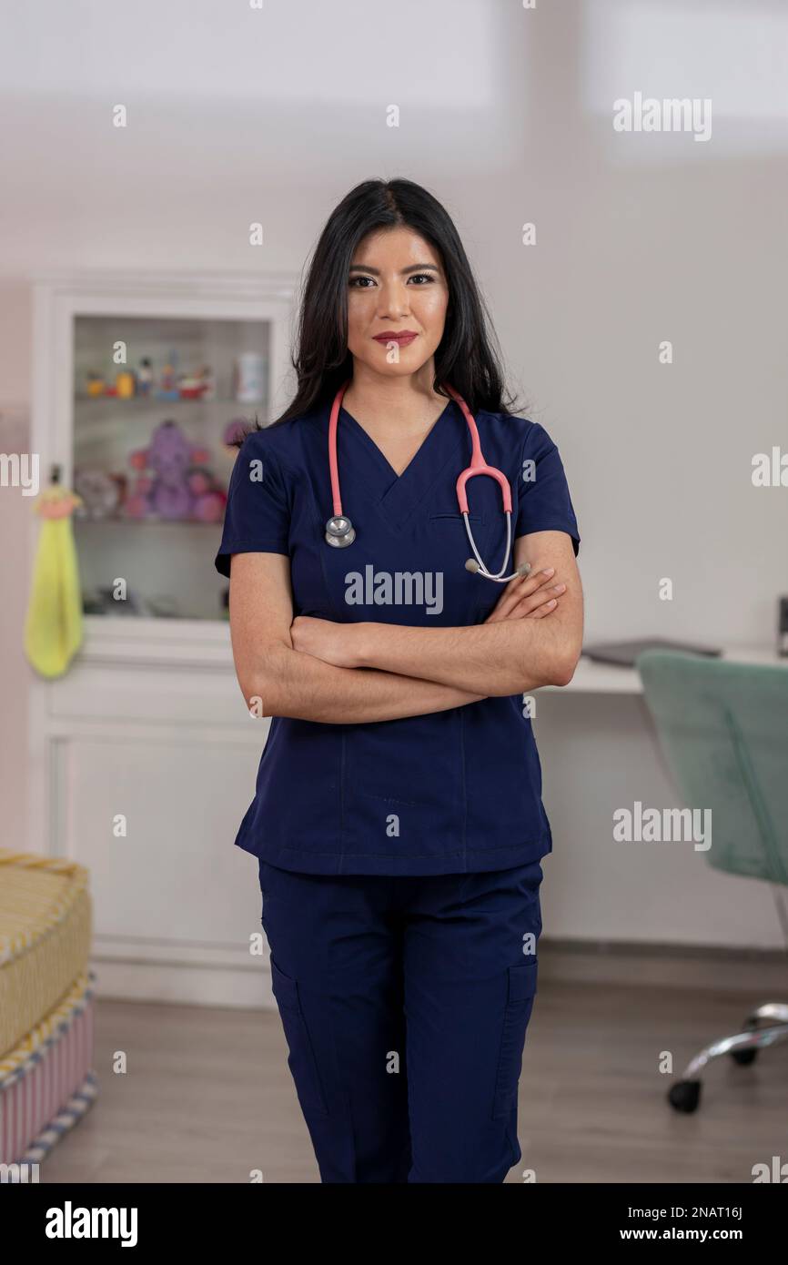 Young Latina doctor, looking at the camera with her arms crossed, in ...