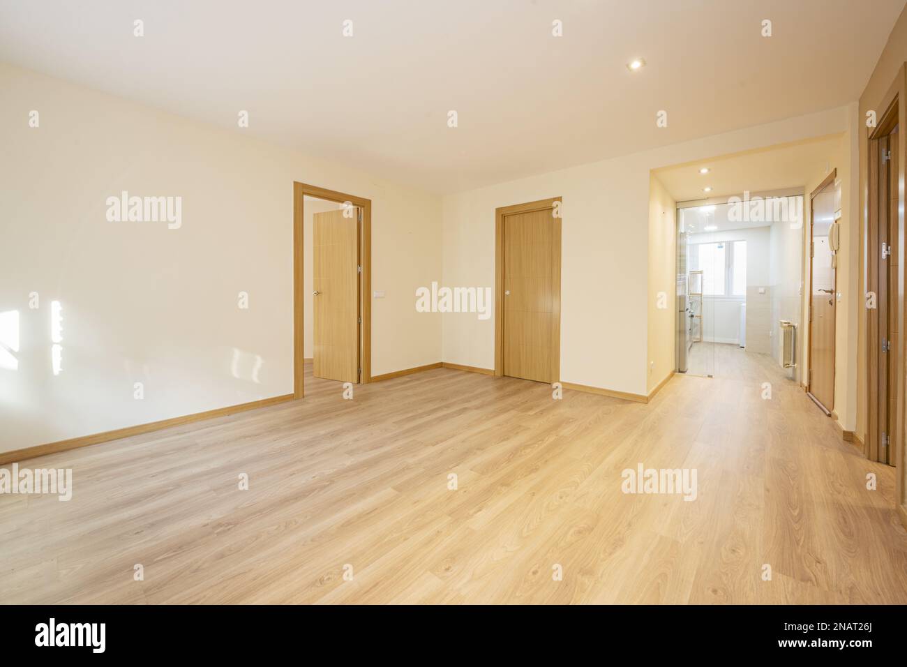 Empty living room with floating oak flooring, access doors to other ...