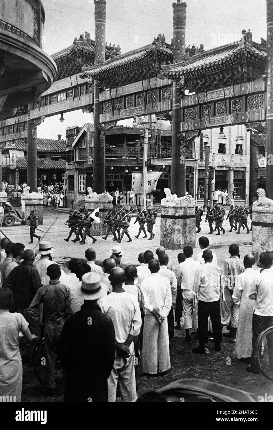 Chinese inhabitants of Peking are seen watching in silence as Japanese ...