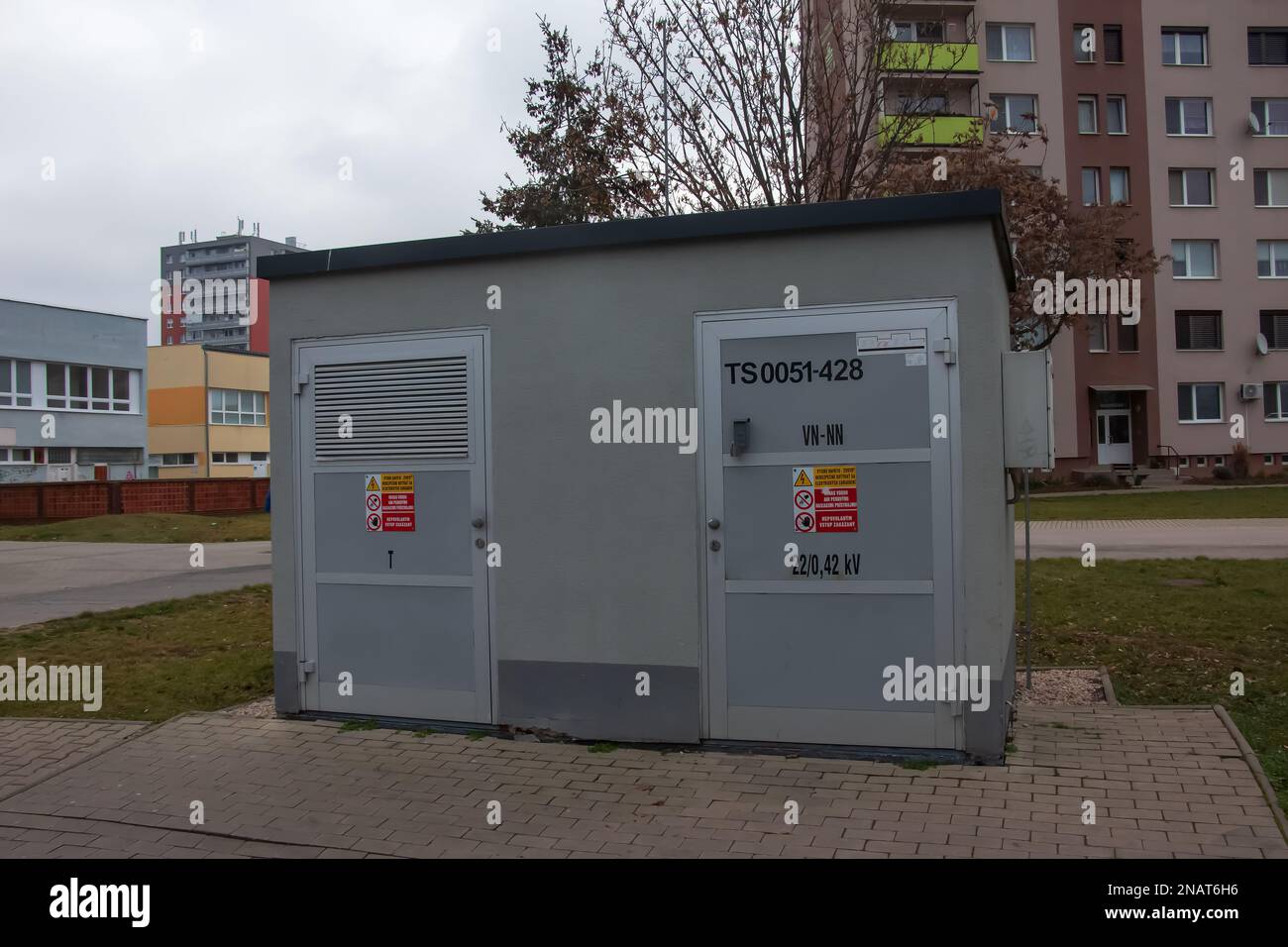 Electric transformer room building with gray doors and yellow danger ...
