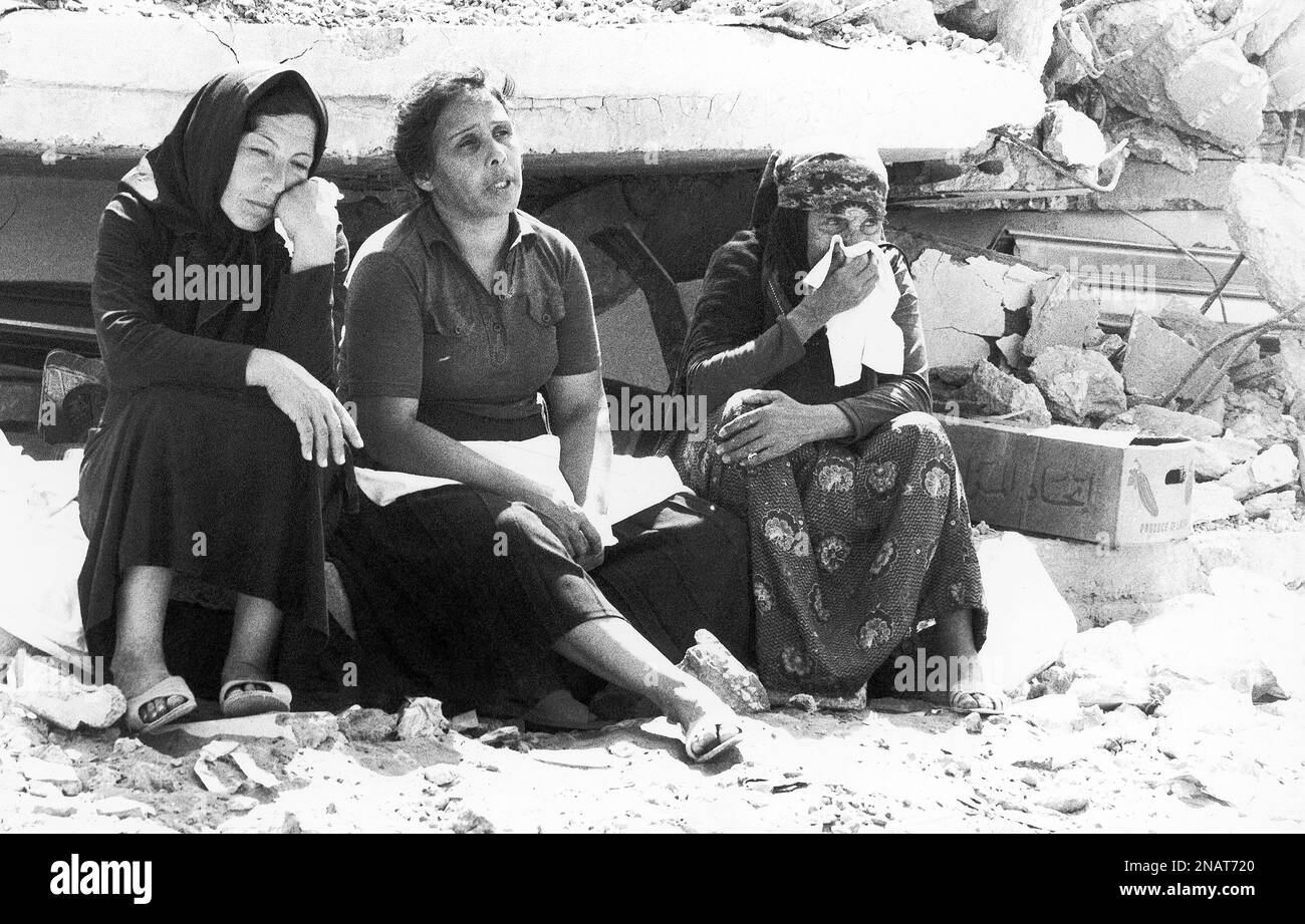 Three Palestinian women sit sadly in the ruins of Sabra PLO Camp in ...