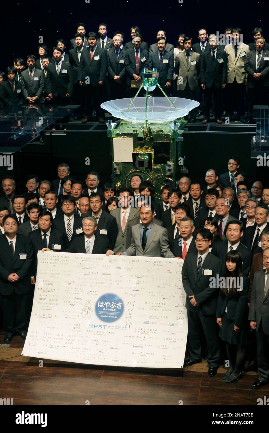 Gathering around a life-sized scale model of the Hayabusa spacecraft of ...