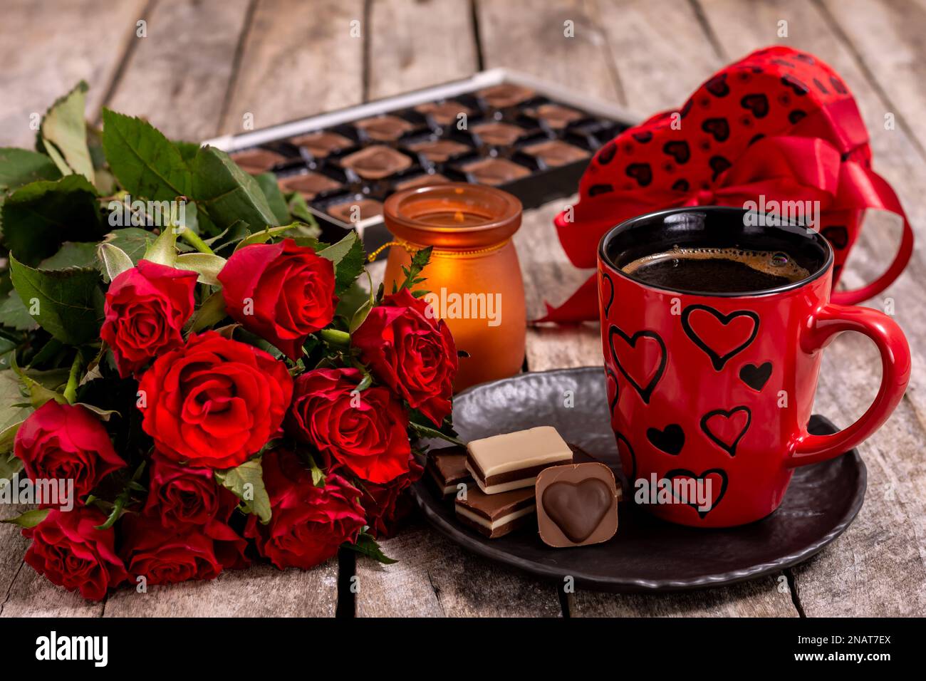 Bouquet of red roses, gift box, candle, cup of coffee and chocolate ...