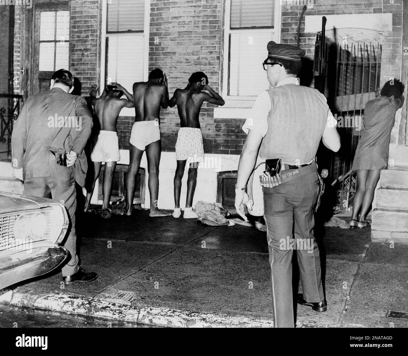 Police lineup suspects against a wall, including a woman at right in ...