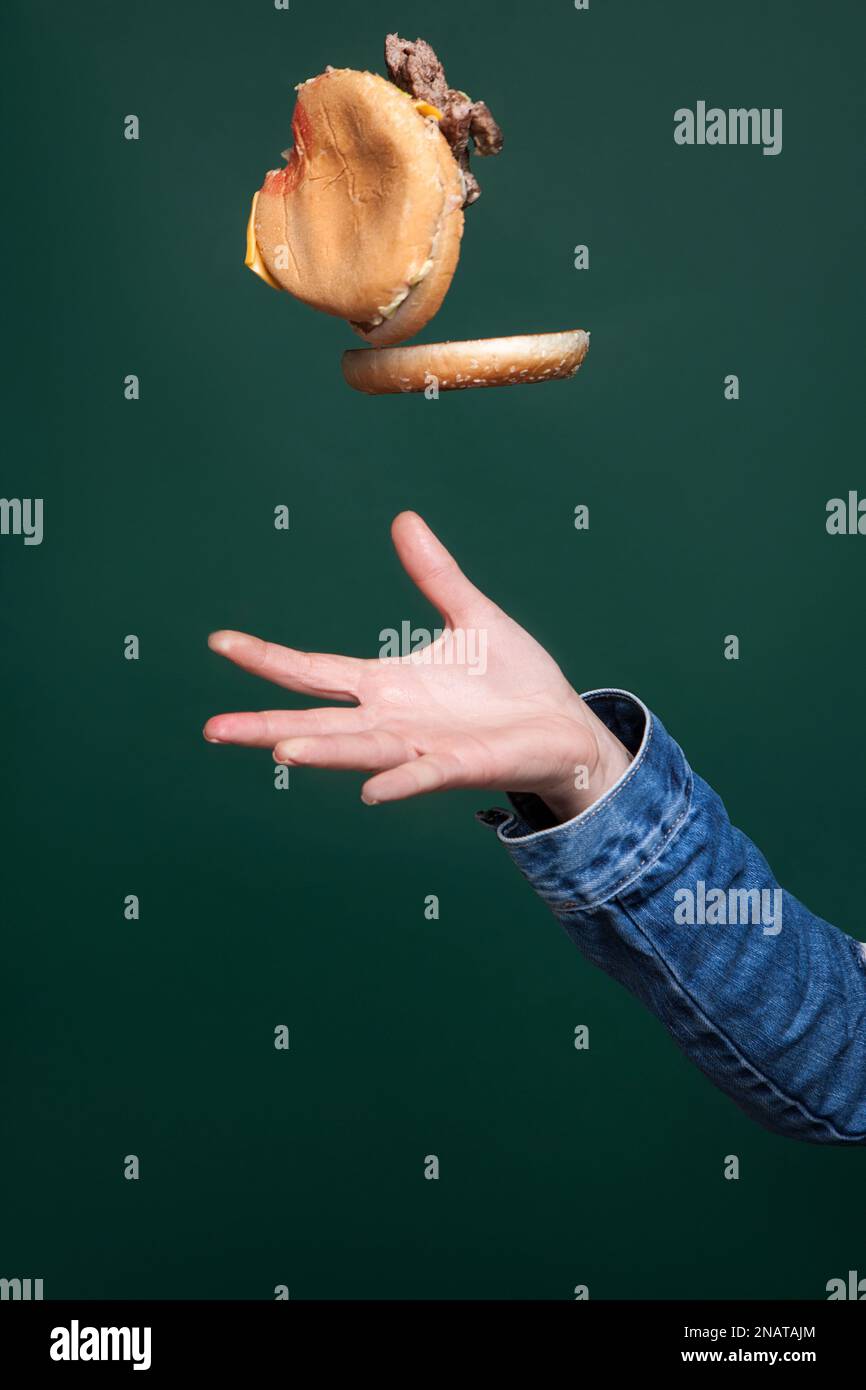 Burger thrown on by hand Stock Photo - Alamy
