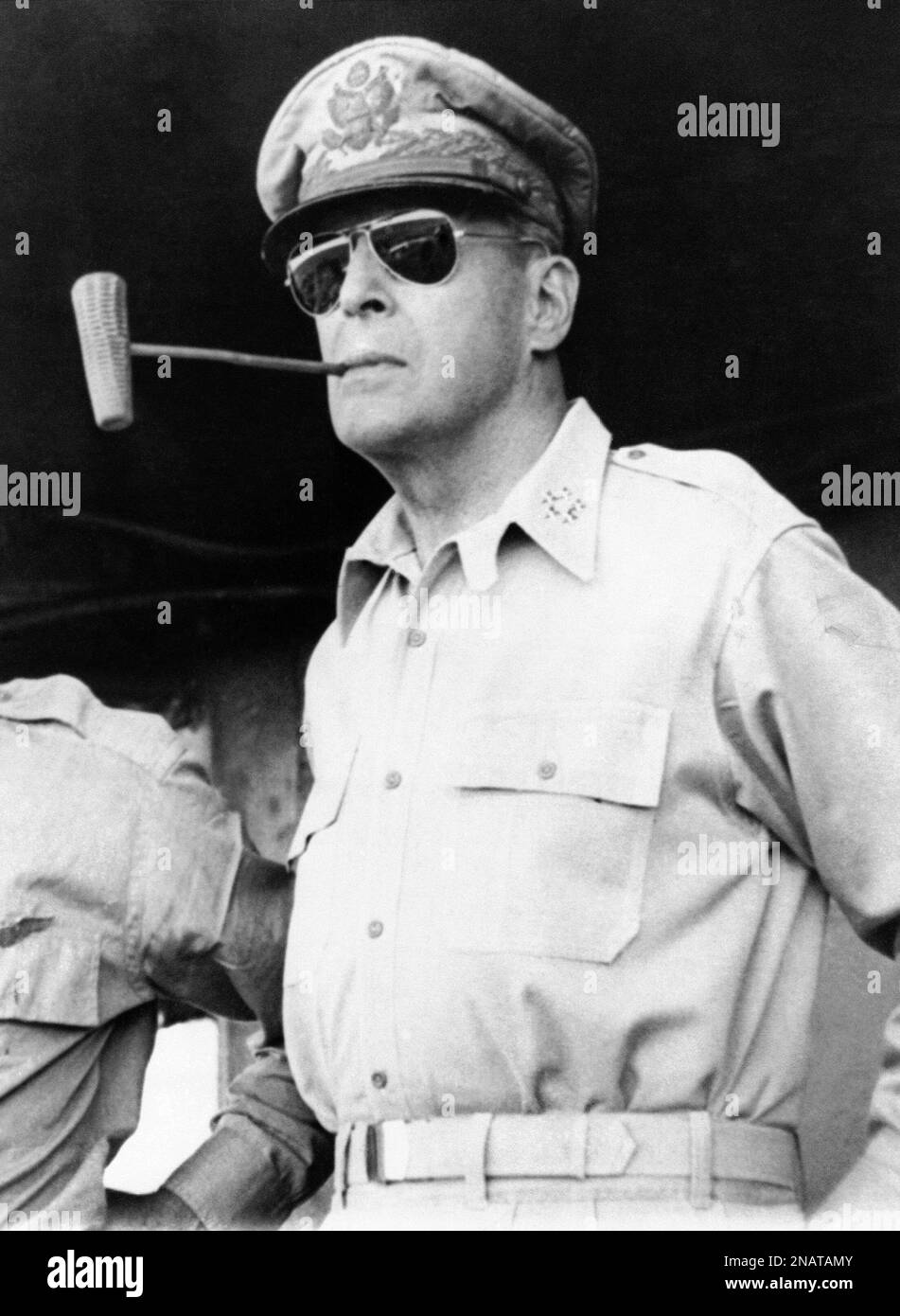 Douglas MacArthur smokes one of his favorite corn cob pipes on a ship ...