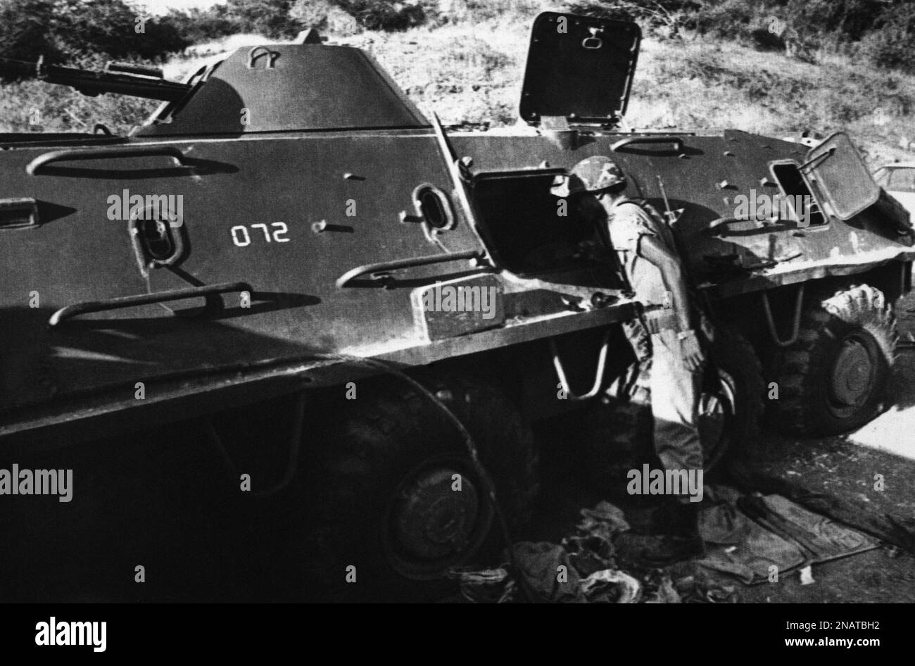 U.S. armed forces troop peers into the window of one of two captured ...