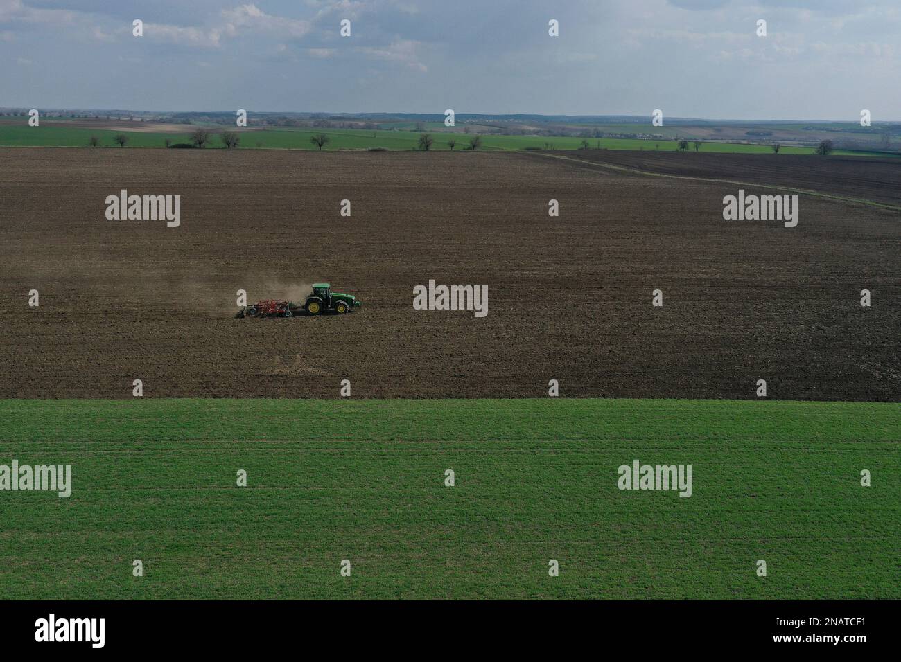 The farmer works with the tractor during the early spring season ...