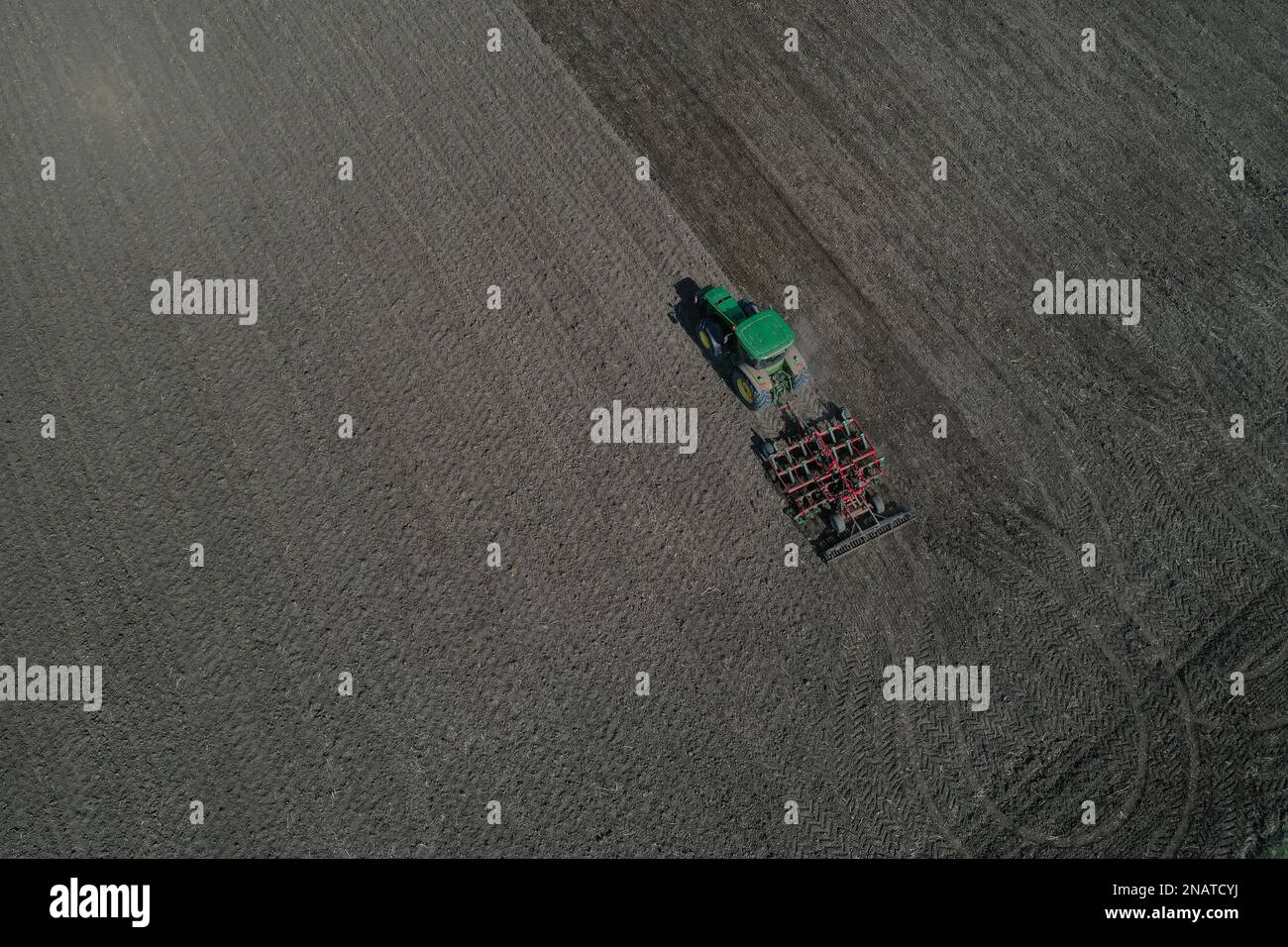 The farmer works with the tractor during the early spring season ...