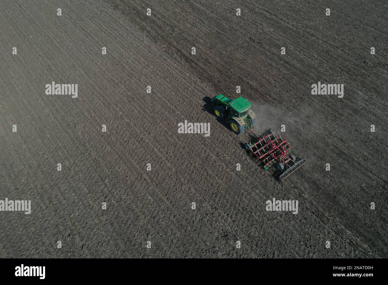 The farmer works with the tractor during the early spring season ...