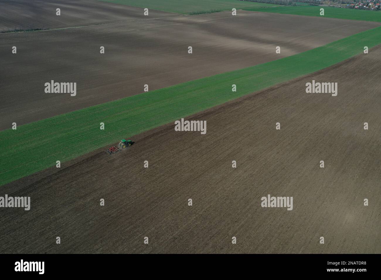 The farmer works with the tractor during the early spring season ...