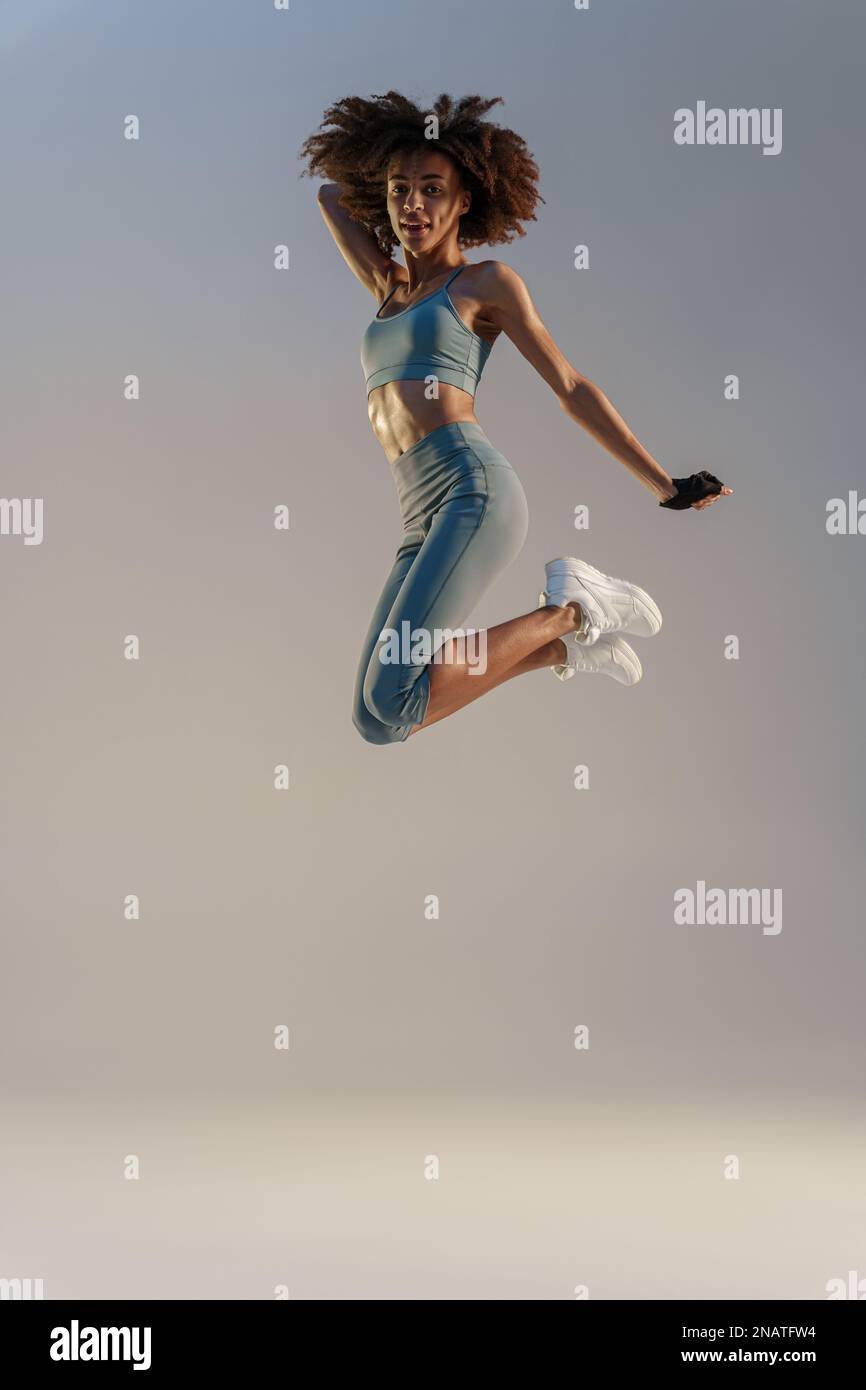 Active sporty woman in sportswear jumping on studio background. Sport ...