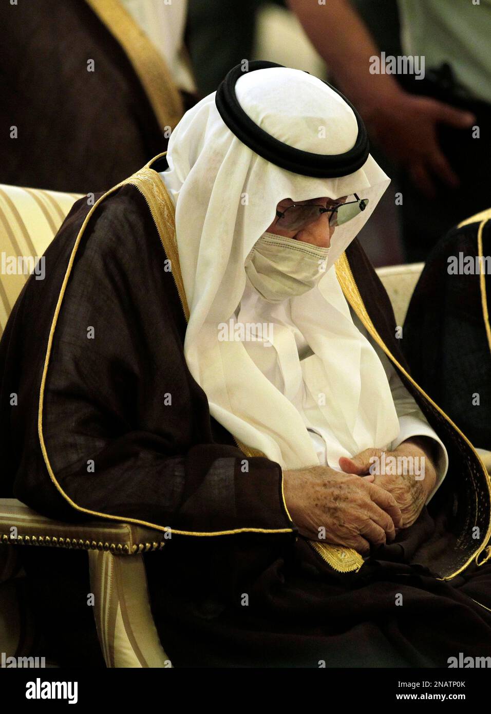 King Abdullah of Saudi Arabia, covers his face with a medical mask as ...