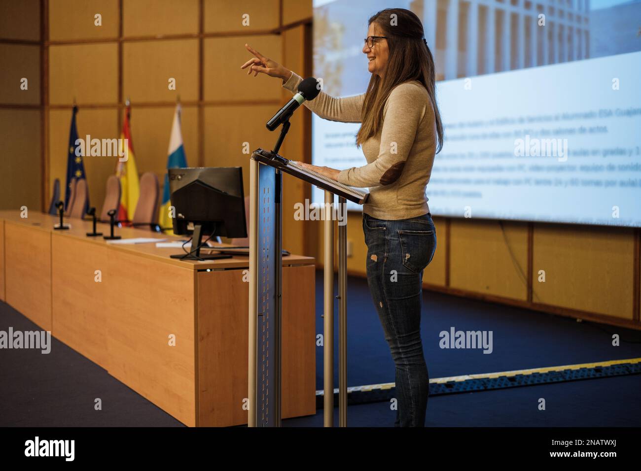 Middle-aged woman standing on the lectern to give a speech to her ...