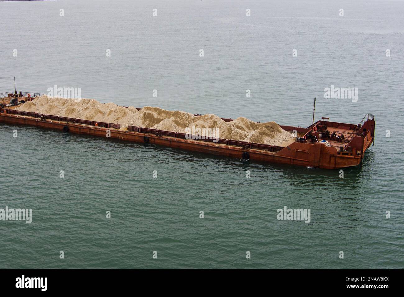 A large barge with soil floats into the sea top view Stock Photo - Alamy