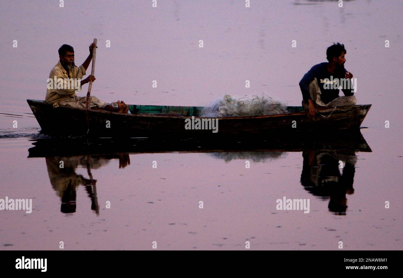 Pakistani fishermen fishing in shallow waters of a sea along the ...