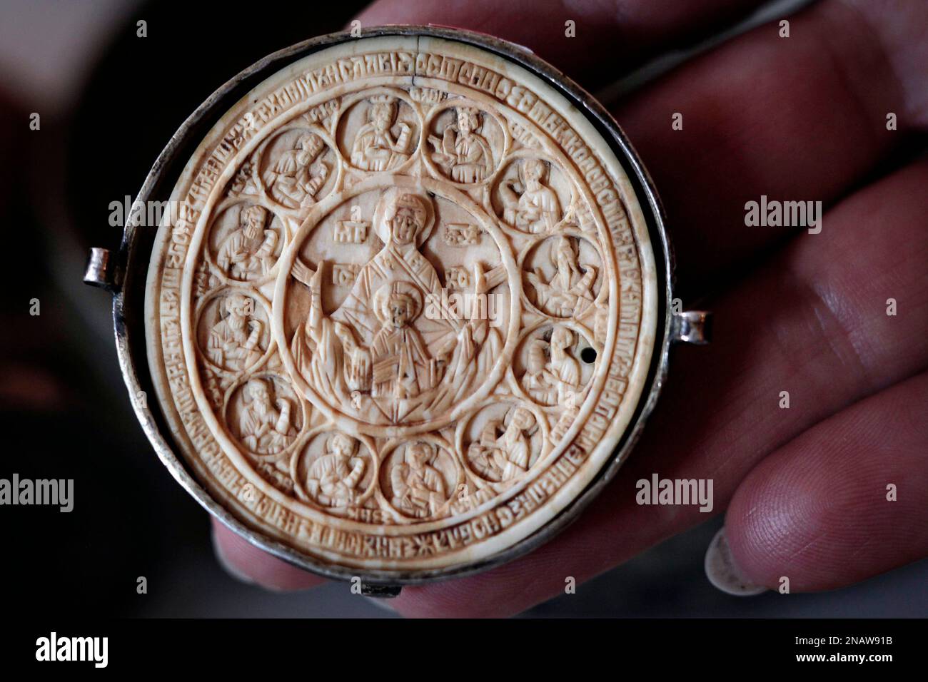 An employee shows part of a 16th century ivory medallion during a ...