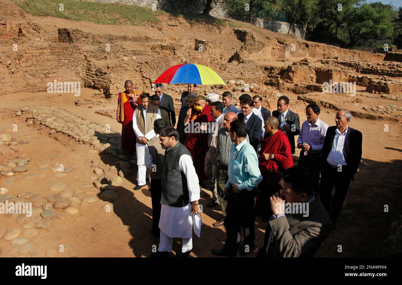 Tibetan spiritual leader the Dalai Lama, center holding umbrella ...